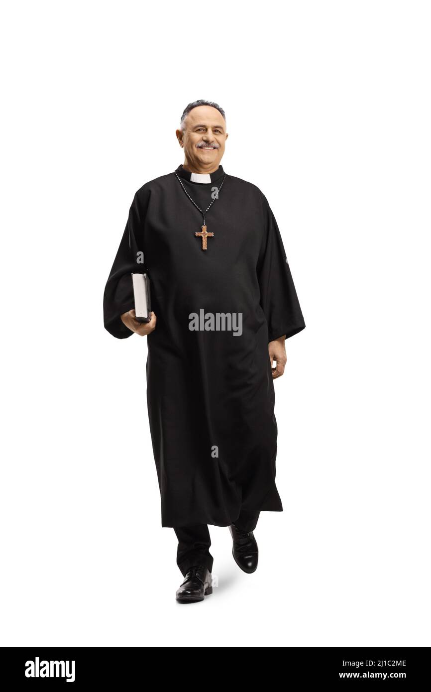 Full length portrait of a priest walking towards camera and holding a ...