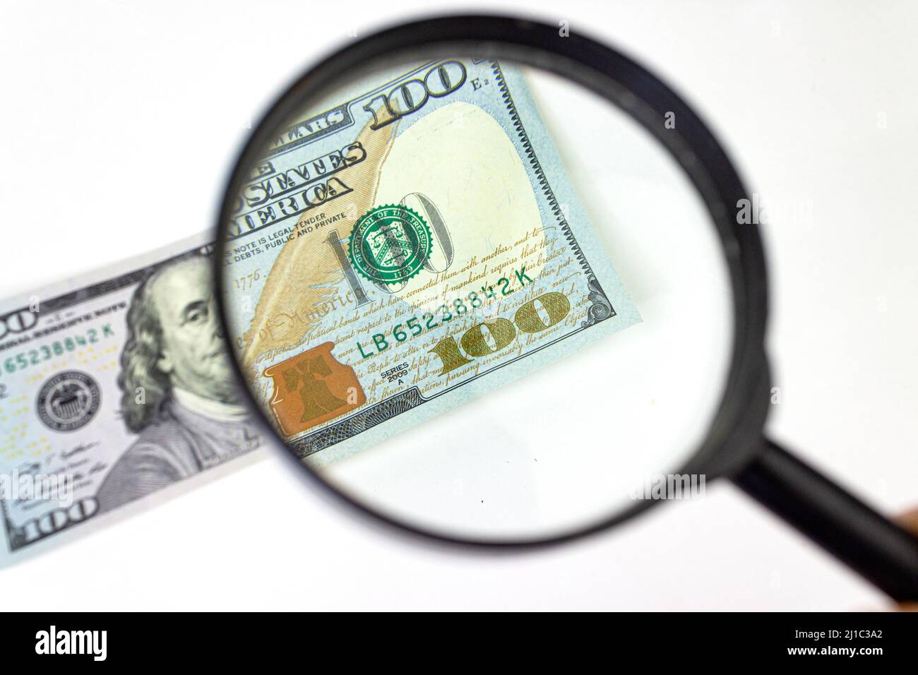 Magnifying glass on dollar banknotes. Magnifying glass on a pile of 100 ...