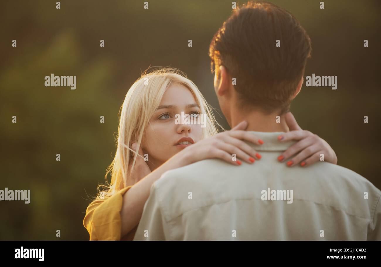 Couple lovers hugging and kissing at sunset. Young couple in love spends time together. Man ...