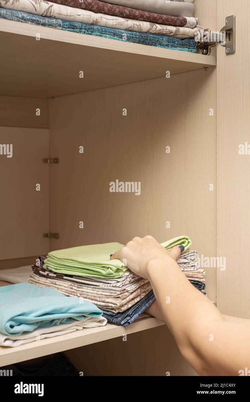 female hands stack folded linen in closet. High quality photo Stock ...