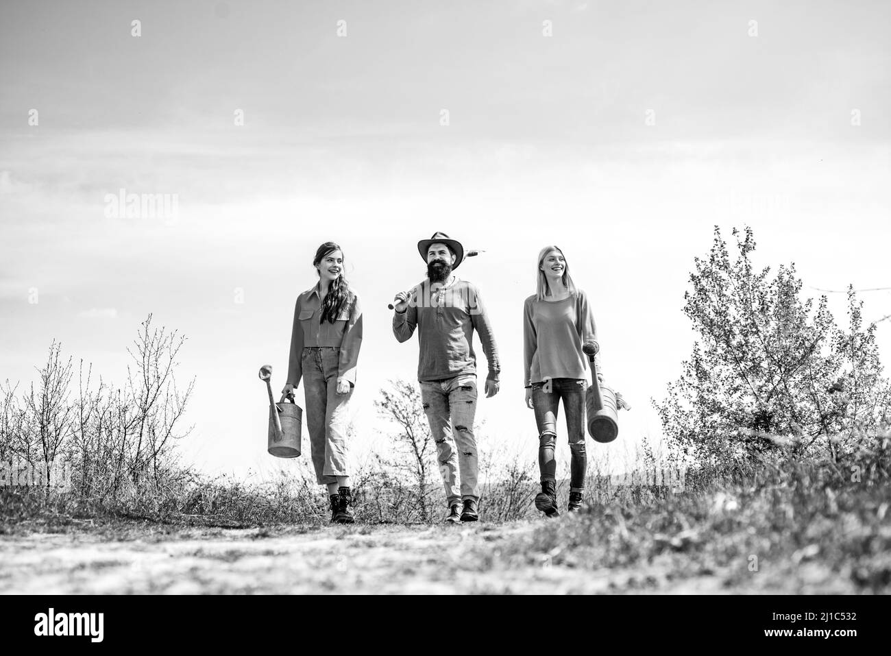 Funny friends walking in spring garden. Friends working in garden ...