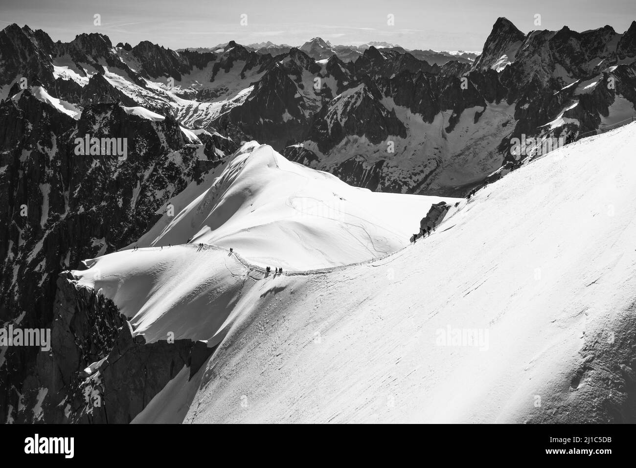 A scenic view of a mountain range peak covered with snow in grayscale ...