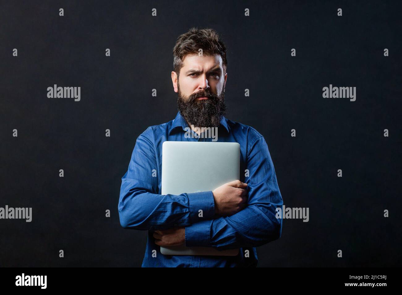 Bearded male businessman holding a computer in his hands isolated on ...
