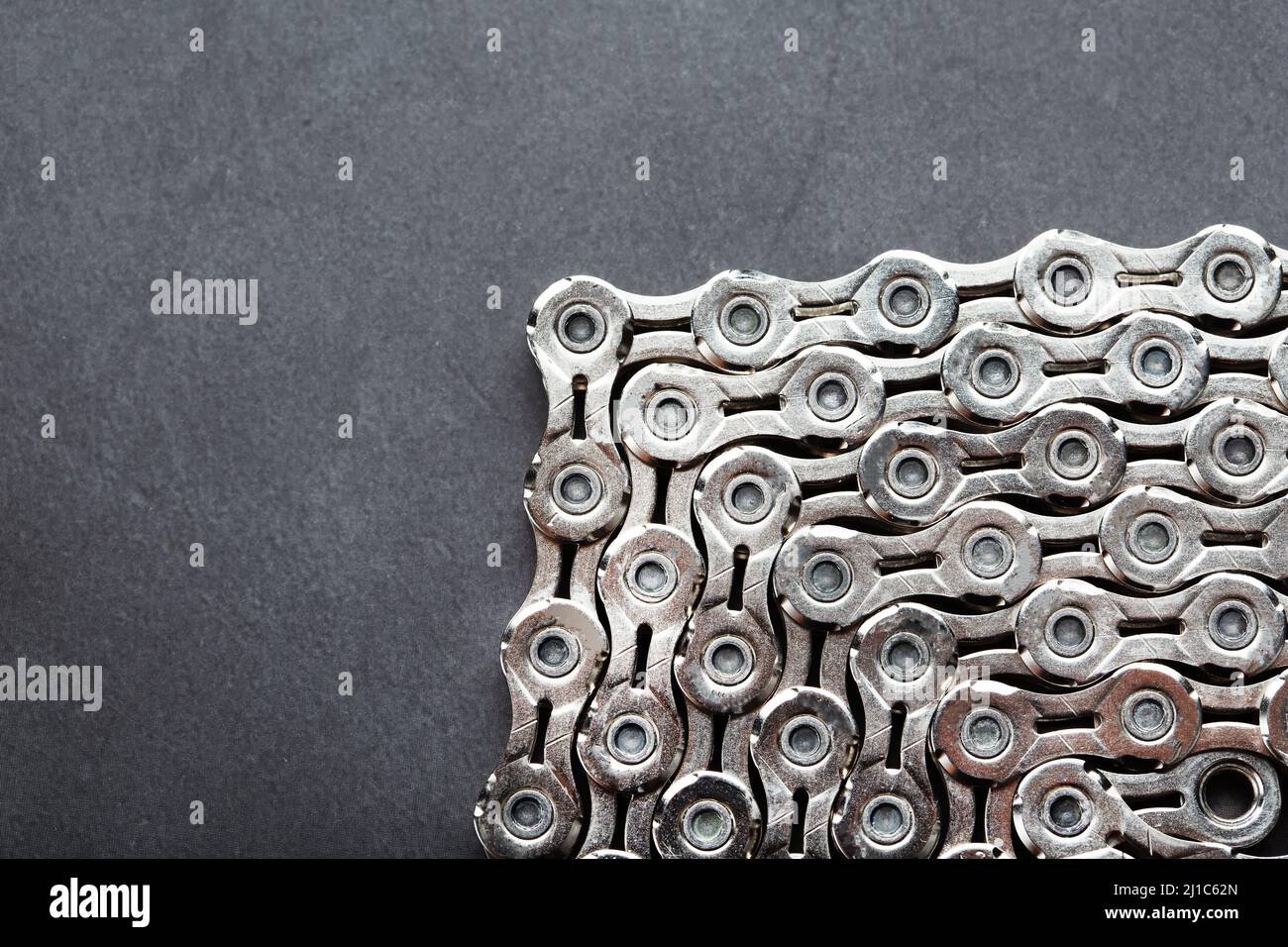 Silver chain of a road bike on a dark textured background with free ...