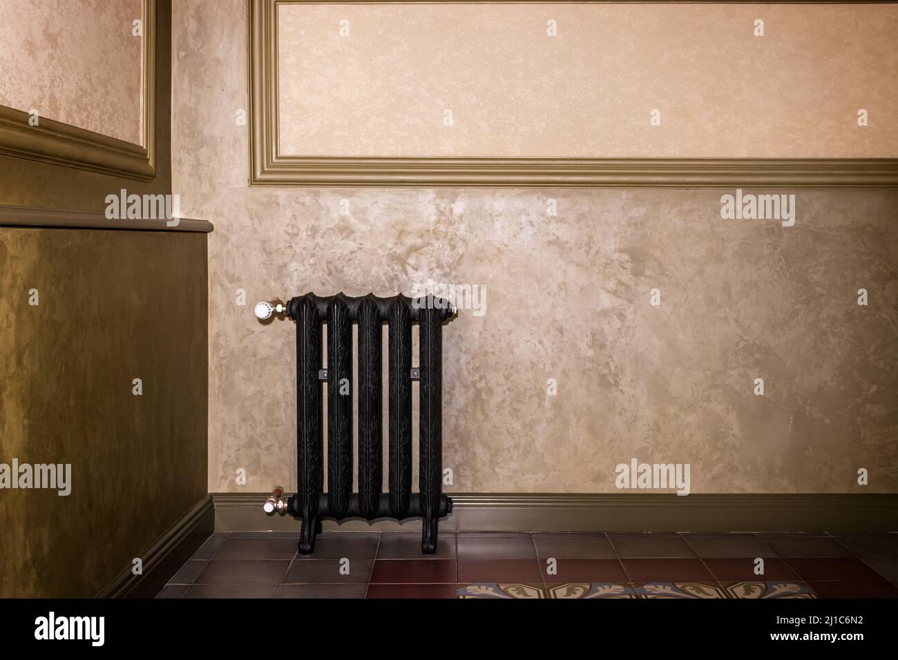 Interior with a black cast-iron radiator in the corner of the room ...