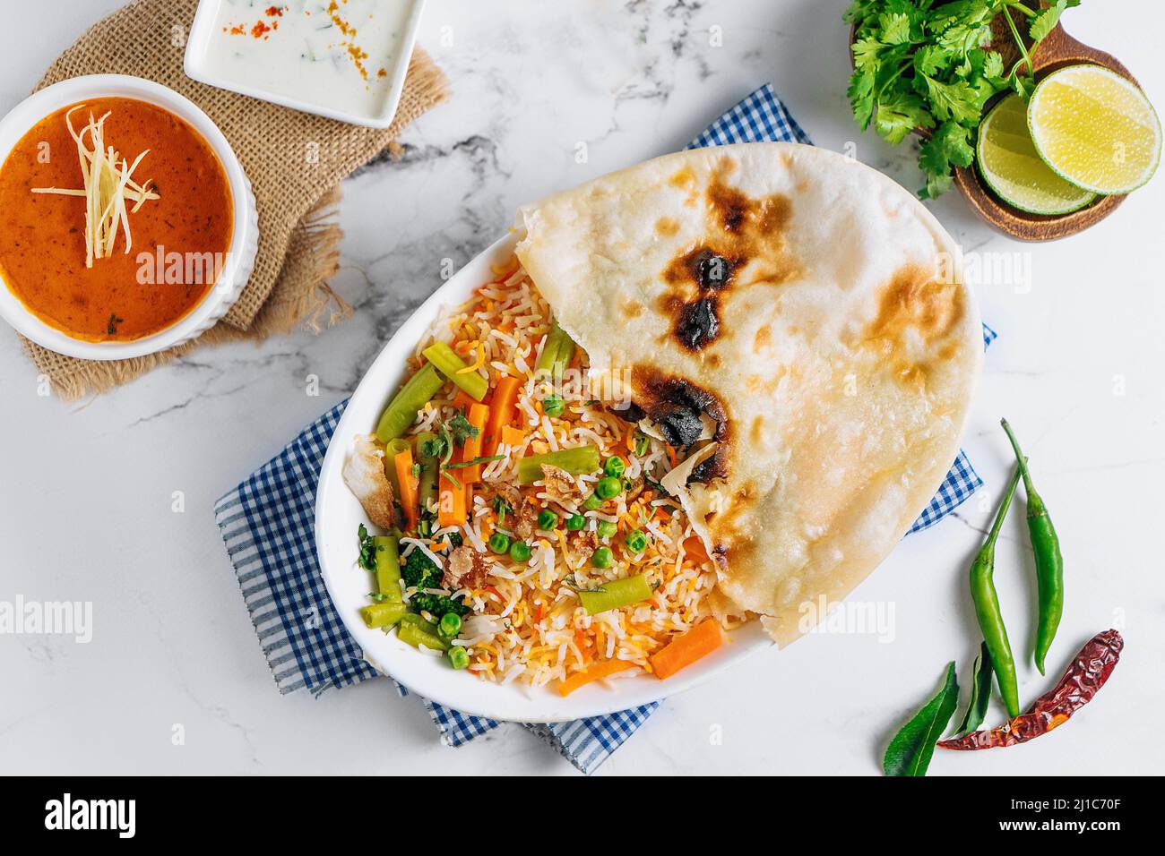 vegetable biryani with raita and sauce in a dish isolated on napkin ...