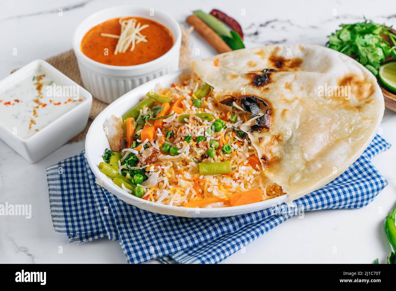 vegetable biryani with raita and sauce in a dish isolated on napkin ...