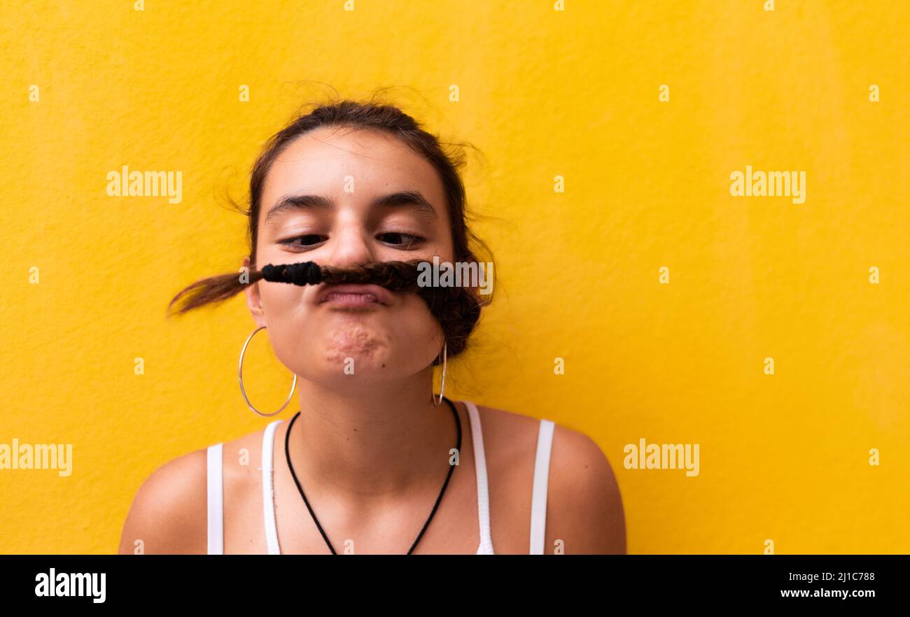 A teenage Caucasian girl doing a duckface and showing a mustache with her hair Stock Photo - Alamy
