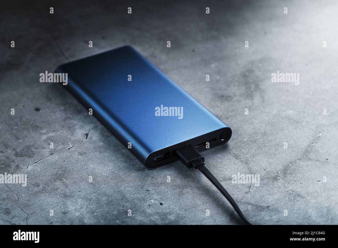 Portable External Battery Power Bank blue with USB Cord on a dark ...