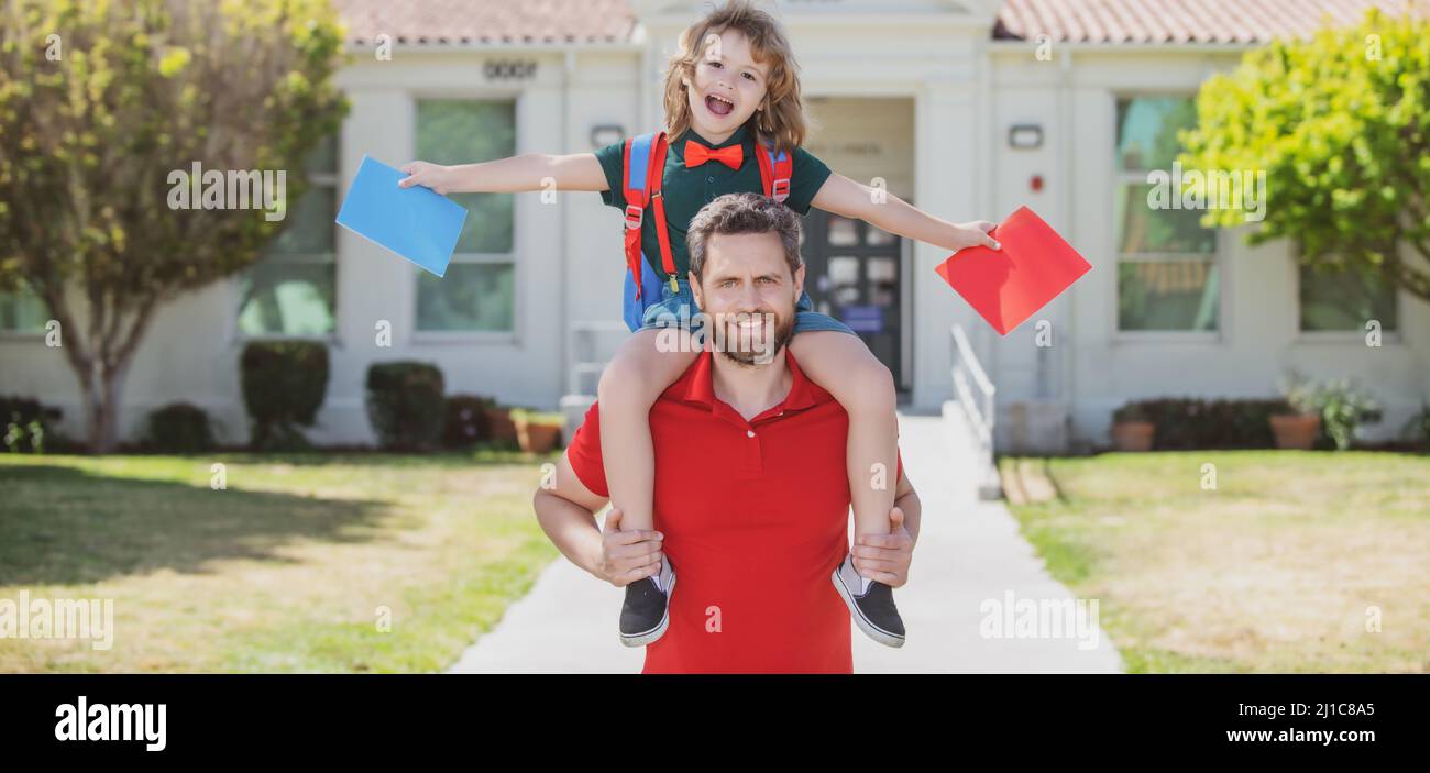 Father piggyback ride son to school. Parent and pupil of primary school ...