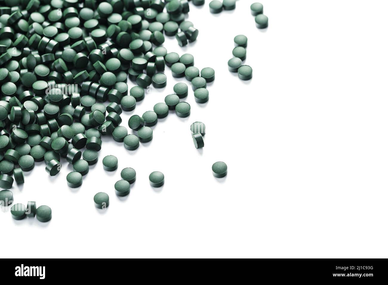 Green tablets made of natural organic spirulina on a white background ...