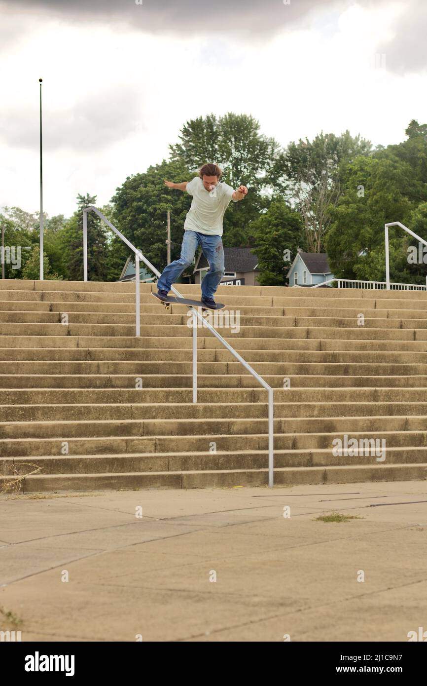 A vertical shot of the skateboarder sliding on the handrail Stock Photo ...
