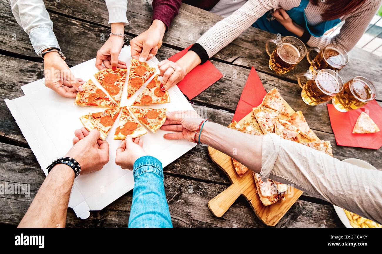 Friends room mates sharing pizza at home garden party - Food life style ...
