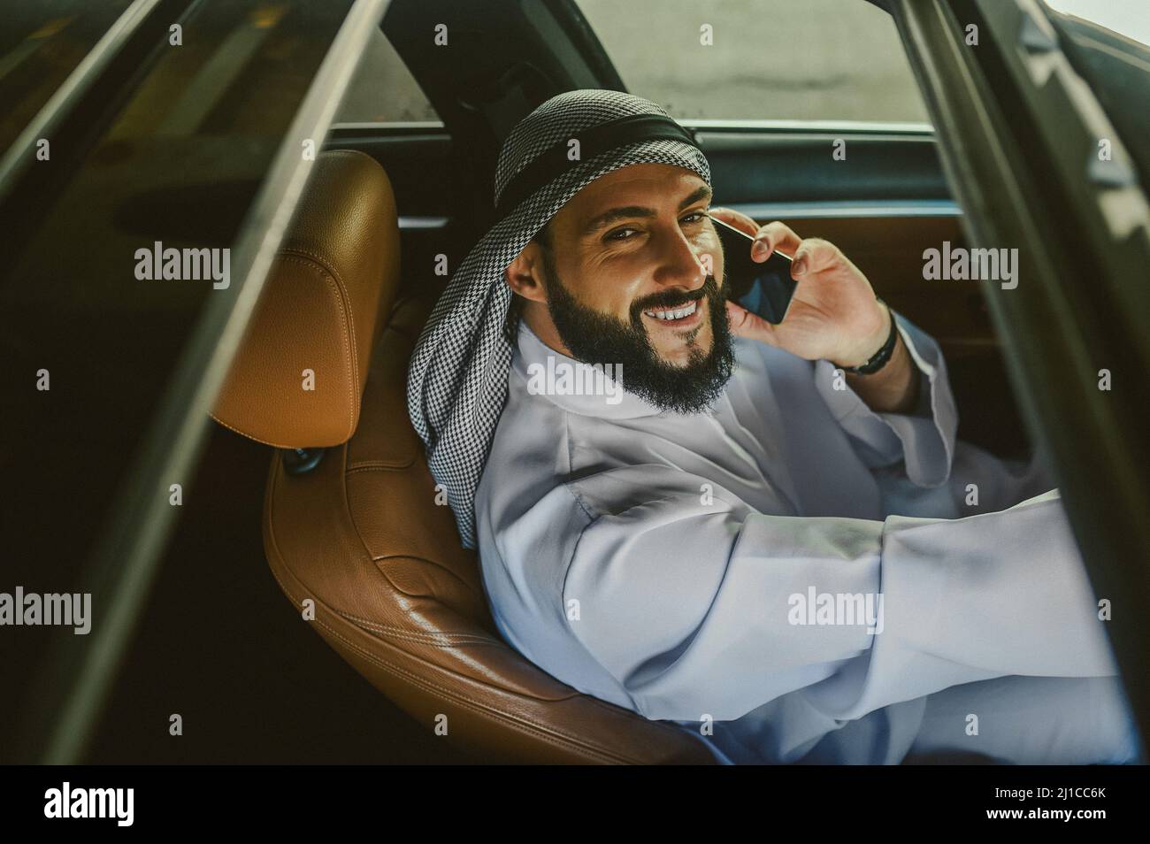 Saudi man sitting in a car and talking on the phone Stock Photo - Alamy