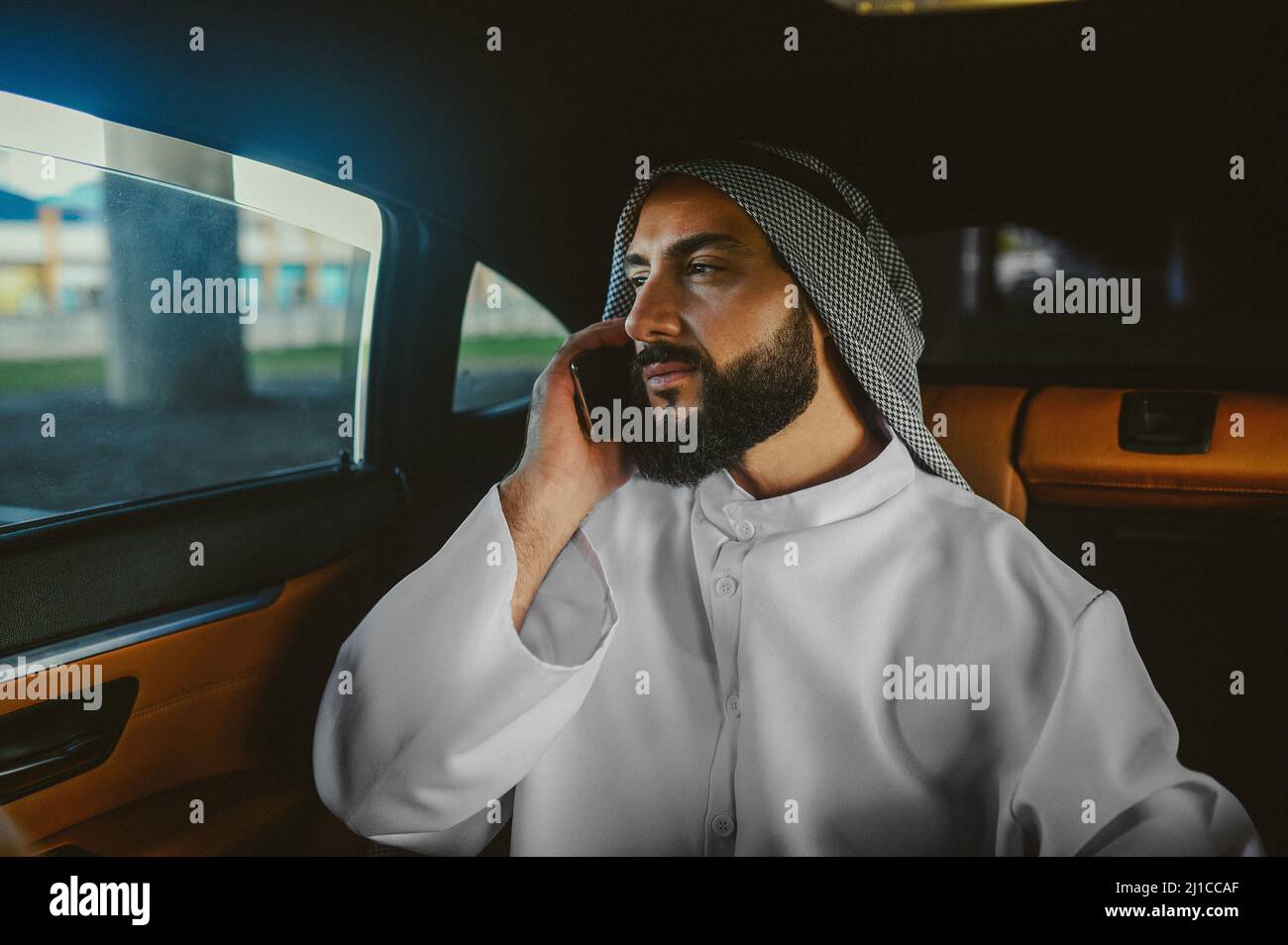 Saudi man sitting in a car and talking on the phone Stock Photo - Alamy
