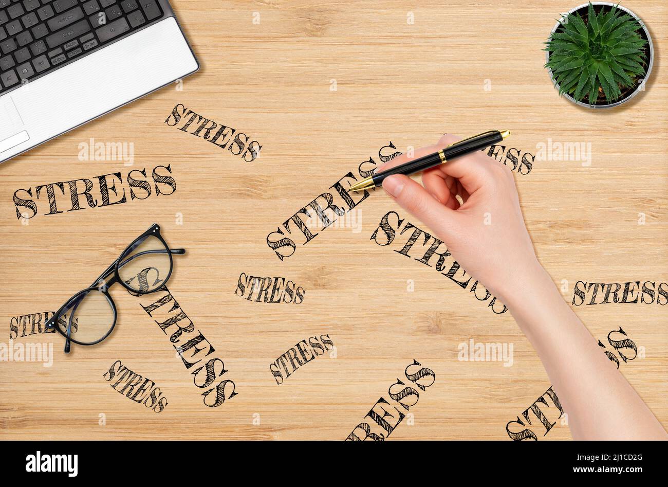 Emotional burnout at work. Female's hand writes STRESS inscriptions on ...