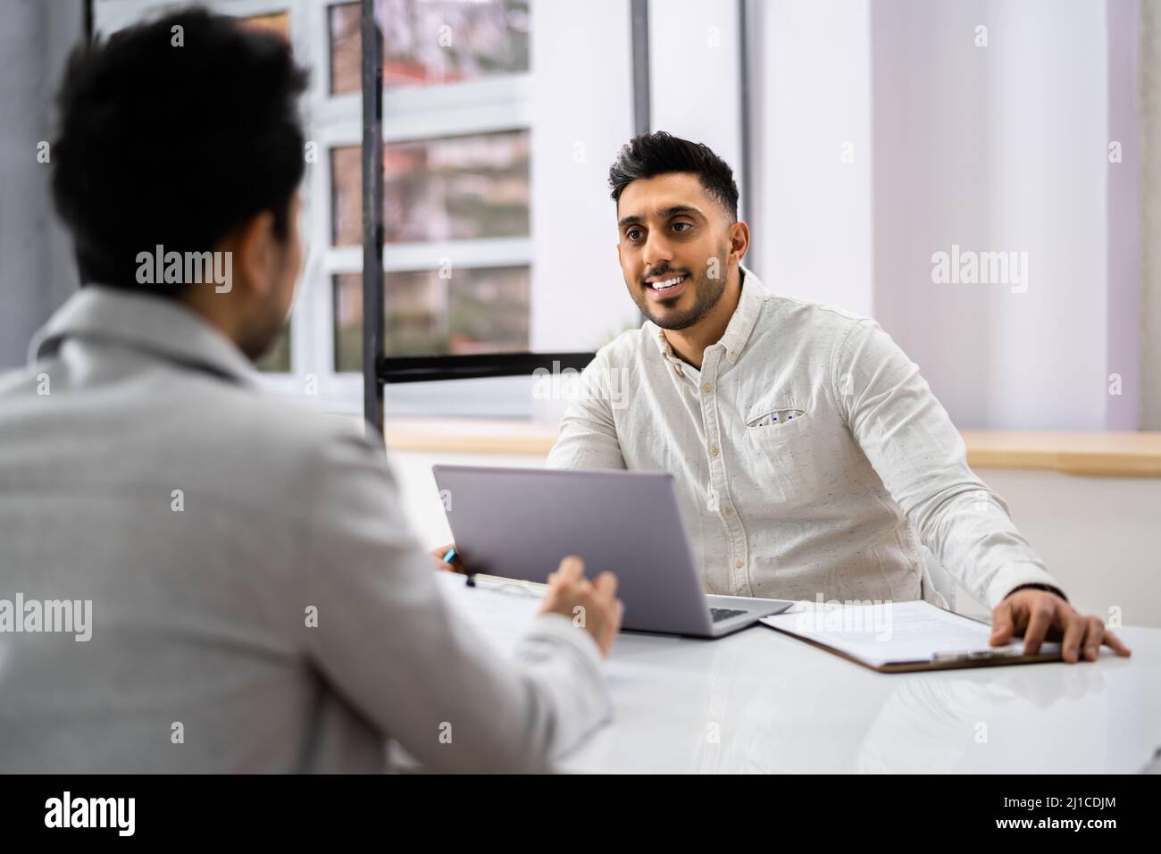 Businessman Conducting An Employment Interview With Young Applicant ...