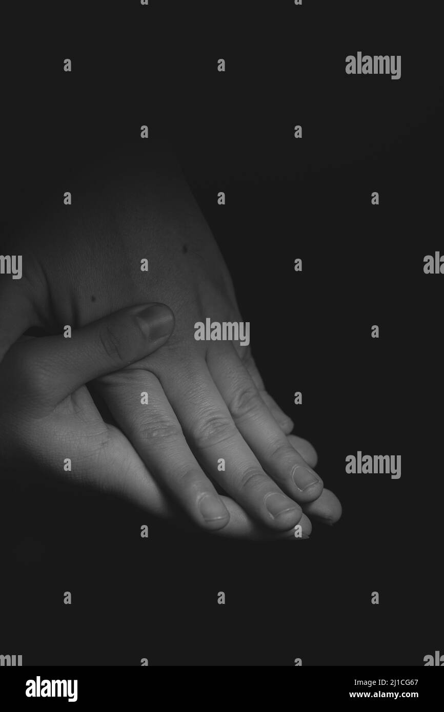 A vertical shot of the dramatic view of the hands in grayscale Stock ...