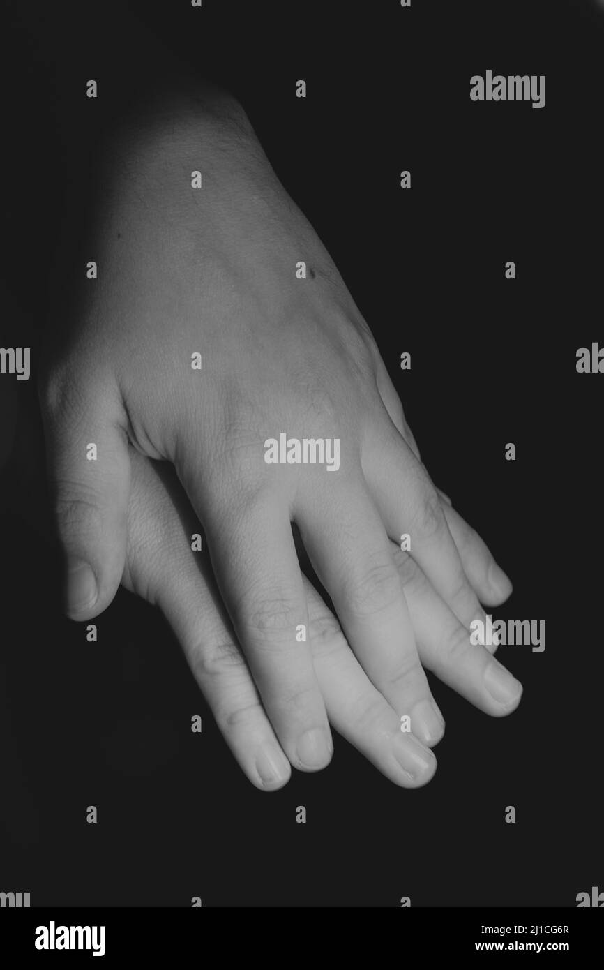A vertical shot of the dramatic view of the hands in grayscale Stock ...