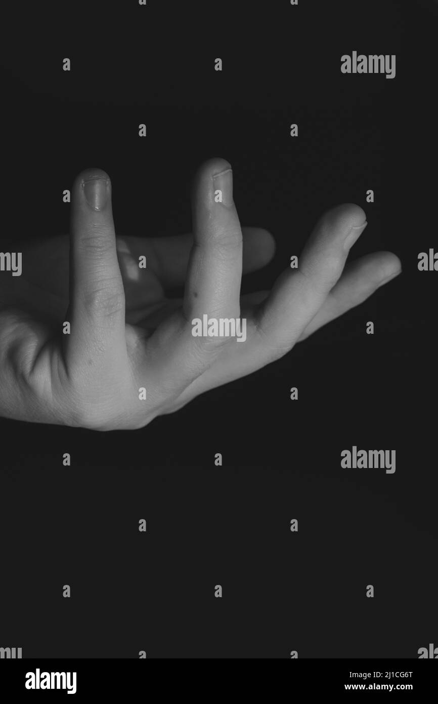 A vertical shot of the dramatic view of the hand in grayscale Stock ...