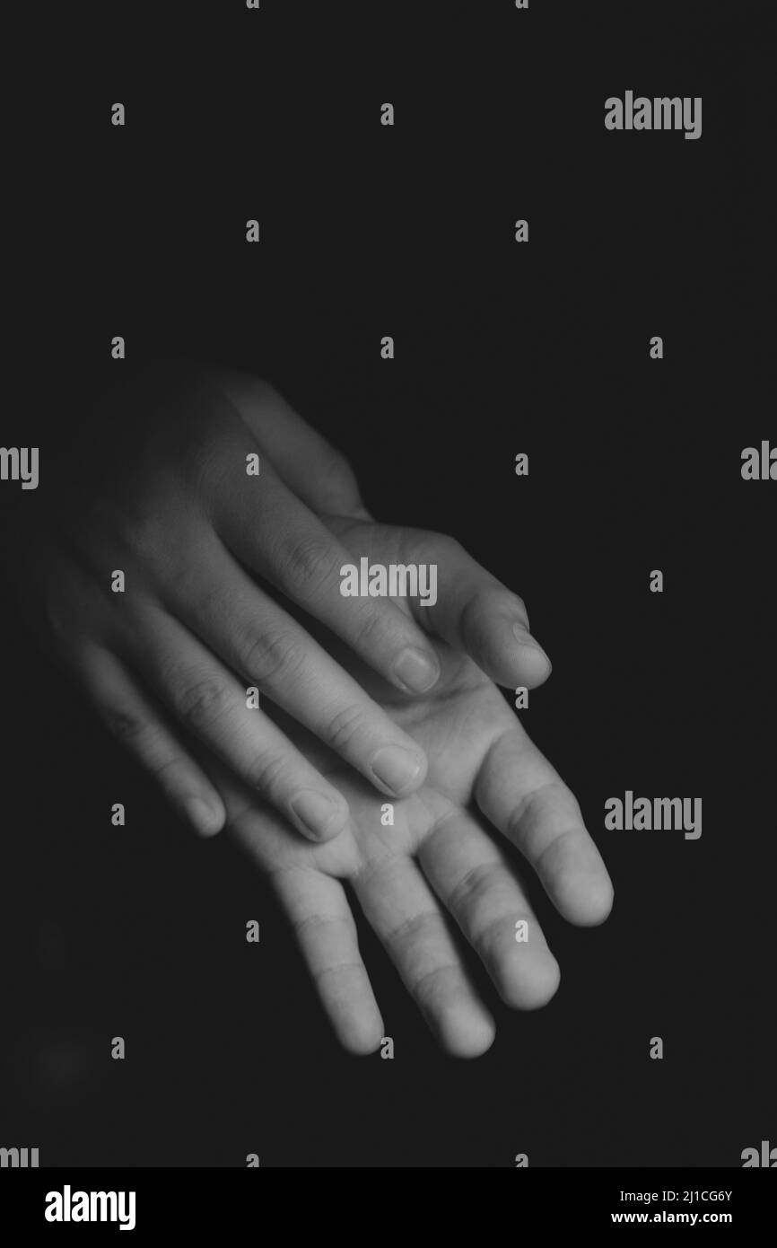 A vertical shot of the dramatic view of the hands in grayscale Stock ...