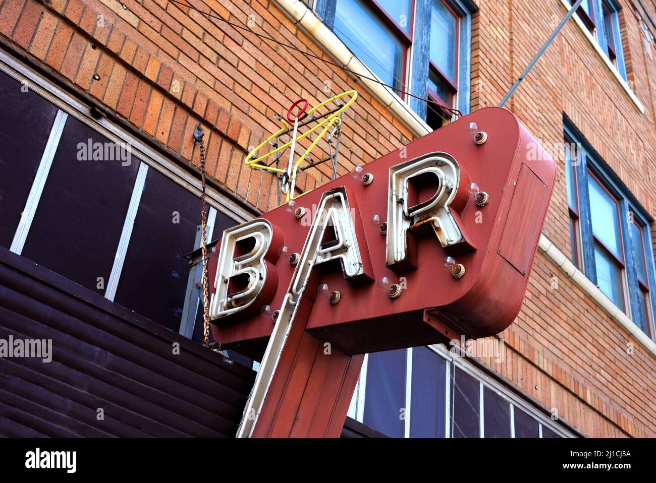 Old neon sign advertises a coctail on exterior of old building. Sign is ...