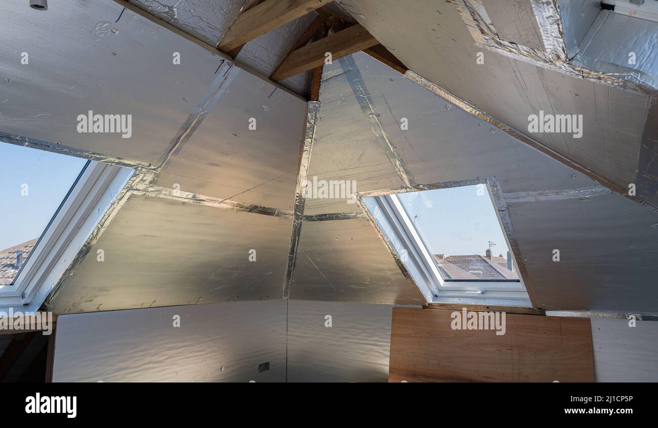 Unfinished residential loft conversion with silver insulation Stock ...
