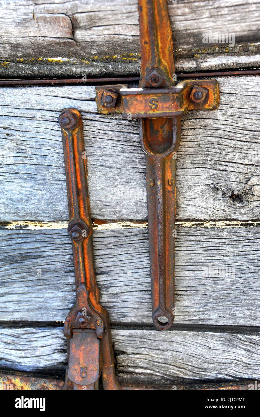 Rusting wagon braces and weathered wood fill background image ...