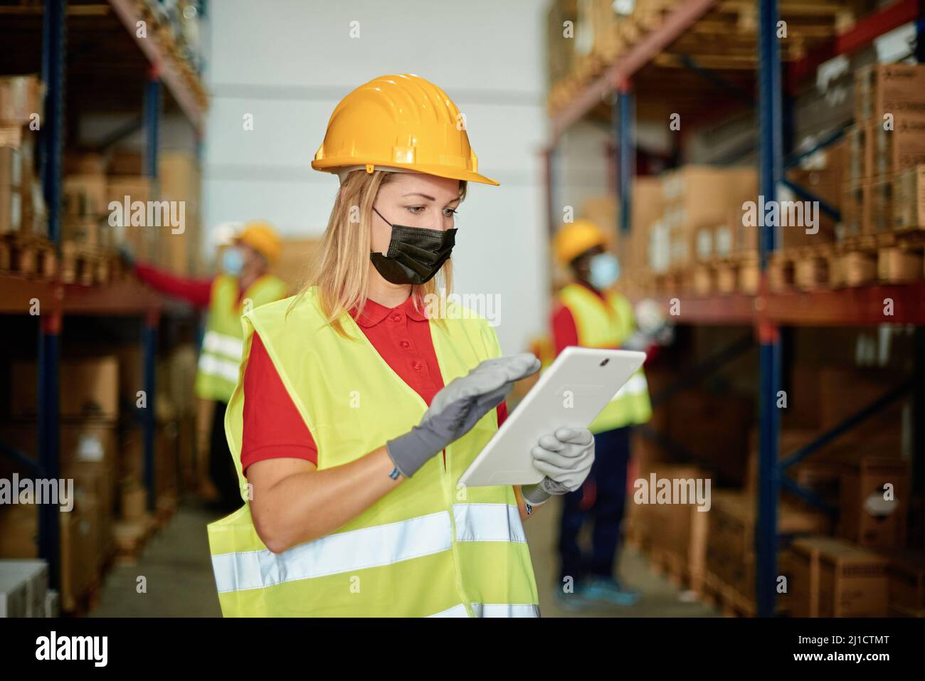 Caucasian female worker checking the order inside a warehouse while ...