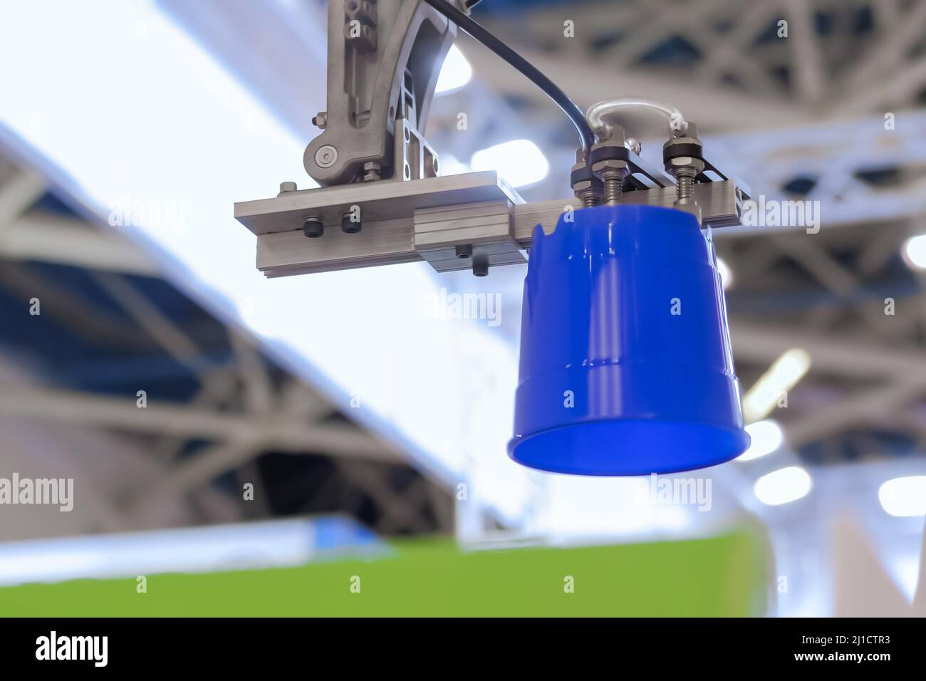 Robotic arm manipulator with suction cups moves purple plastic pots ...