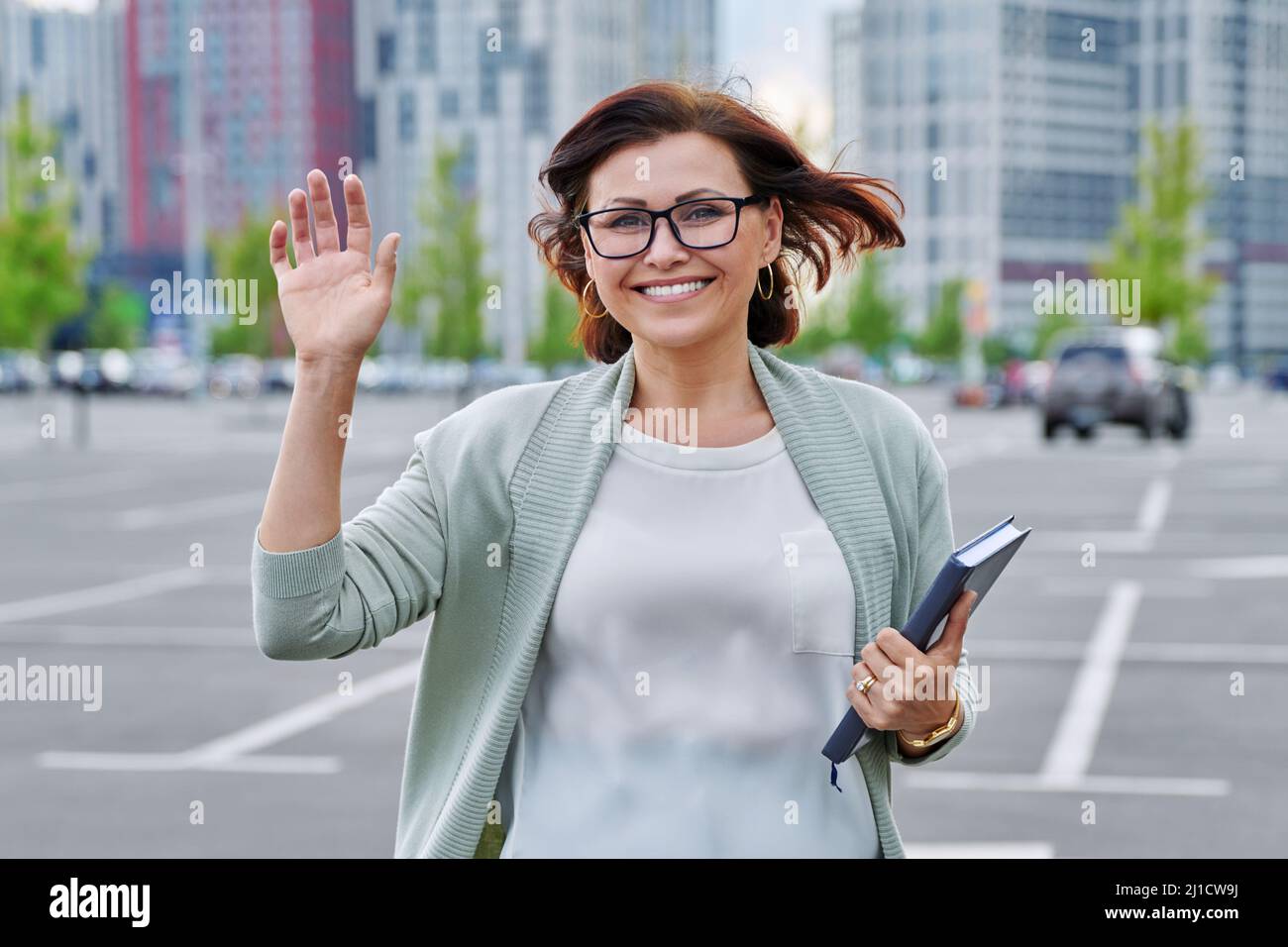 Smiling successful mature business woman walking outdoor, modern urban ... Smiling successful mature business woman walking outdoor, modern urban ...