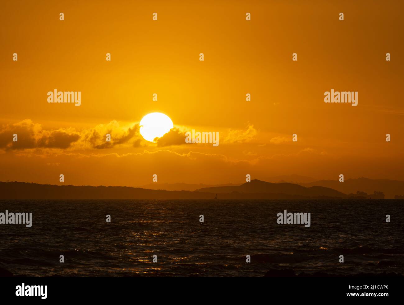 Sun rising over the clouds with distance hills in the horizon. Photo ...