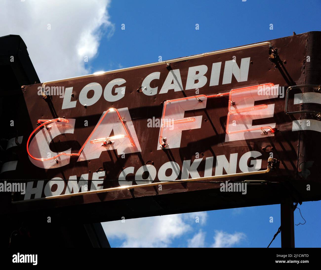 Log Cabin Cafe has neon lighted sign. Sign is metal with pink lighted ...