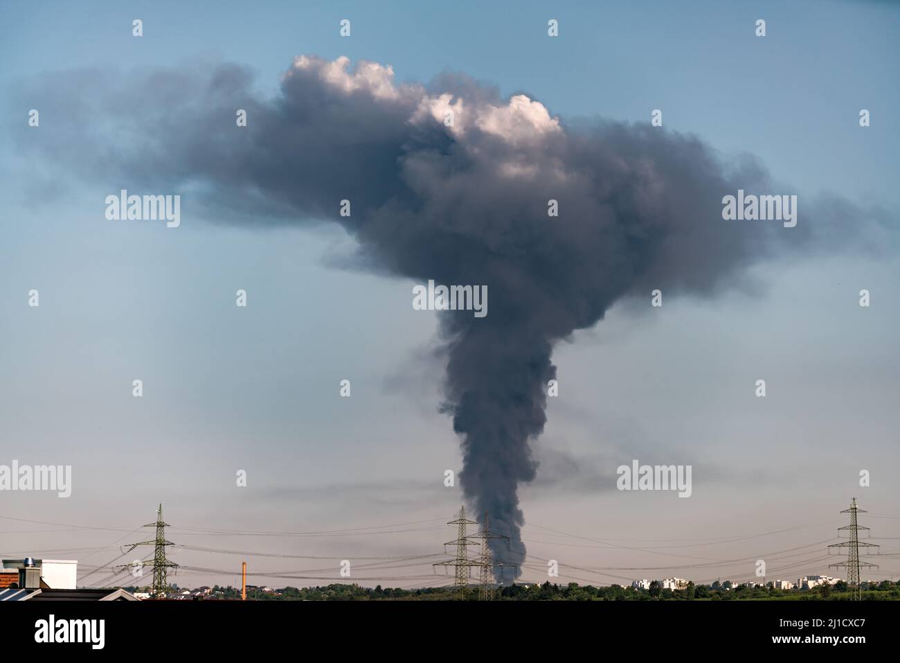 Big gray explosion smoke with electric tower and some green fields in ...