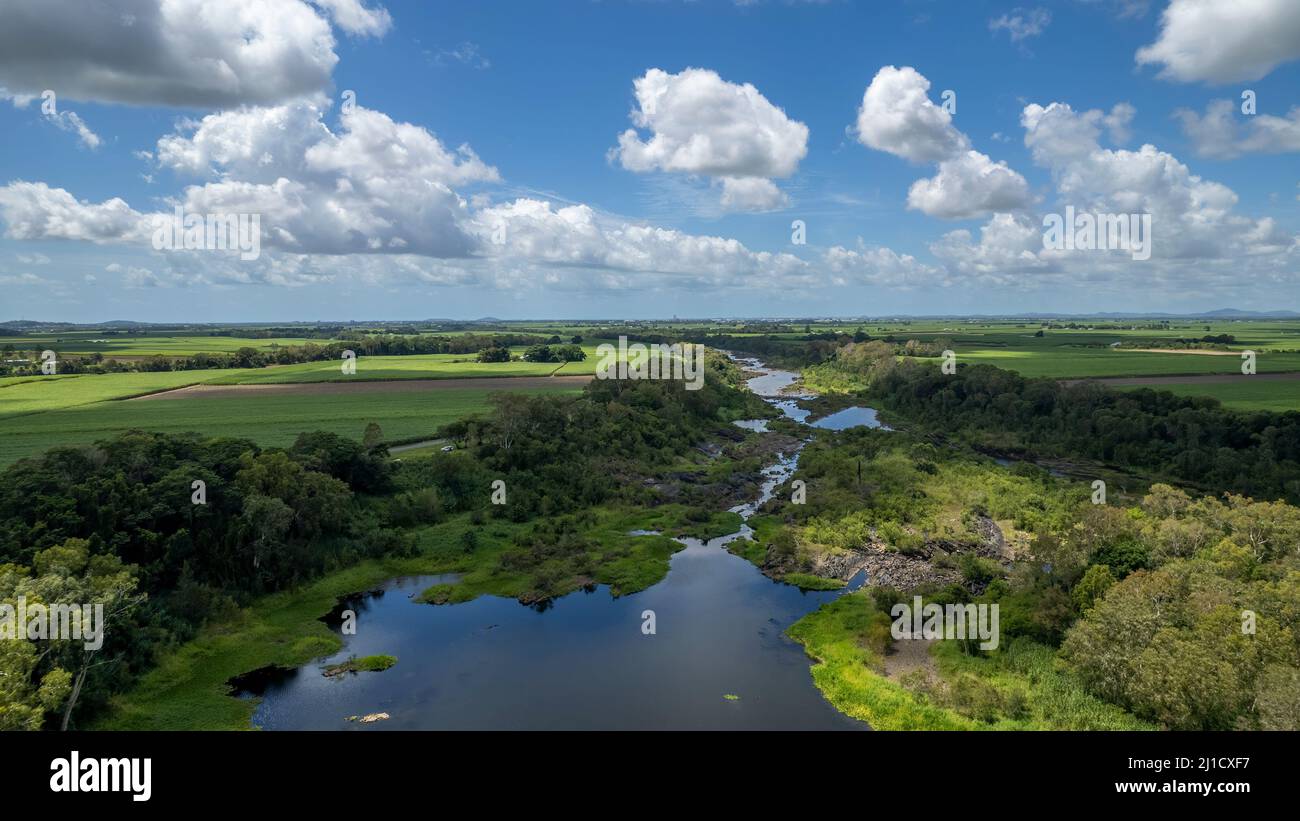 High drone aerial downriver from a dam with small flows of water ...