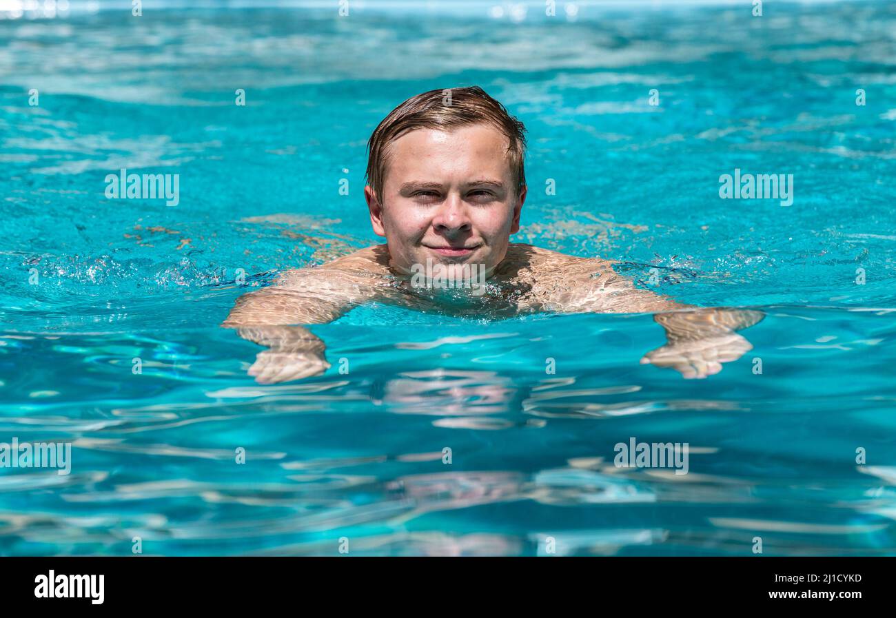 boy enjoys swimming in the outdoor swimming pool Stock Photo - Alamy