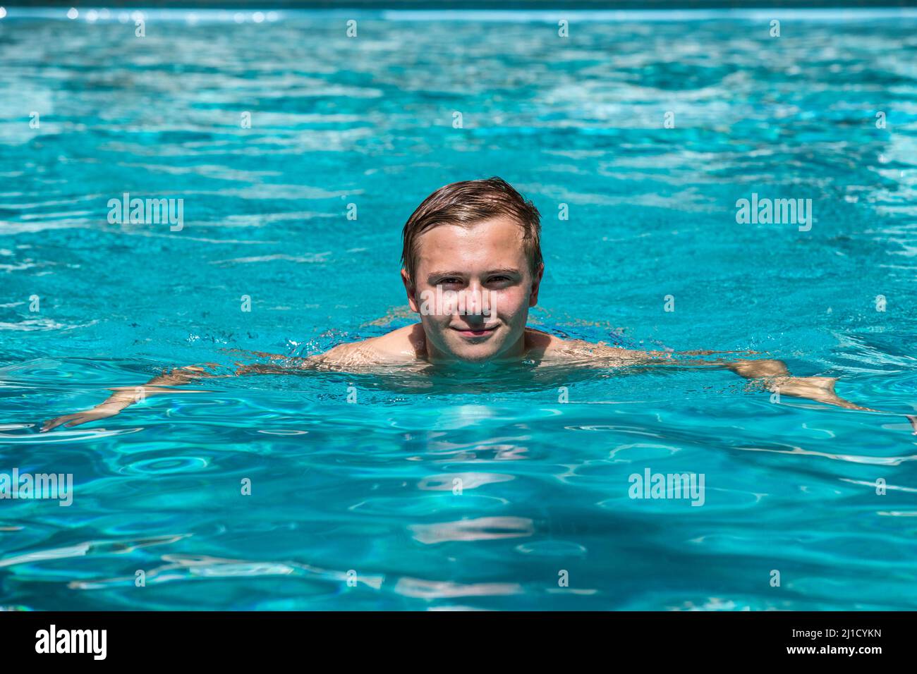 boy enjoys swimming in the outdoor swimming pool Stock Photo - Alamy