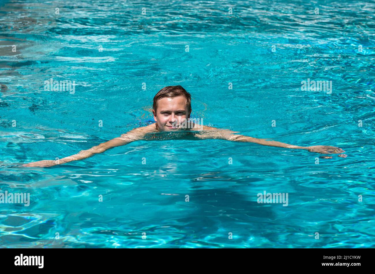 boy enjoys swimming in the outdoor swimming pool Stock Photo - Alamy