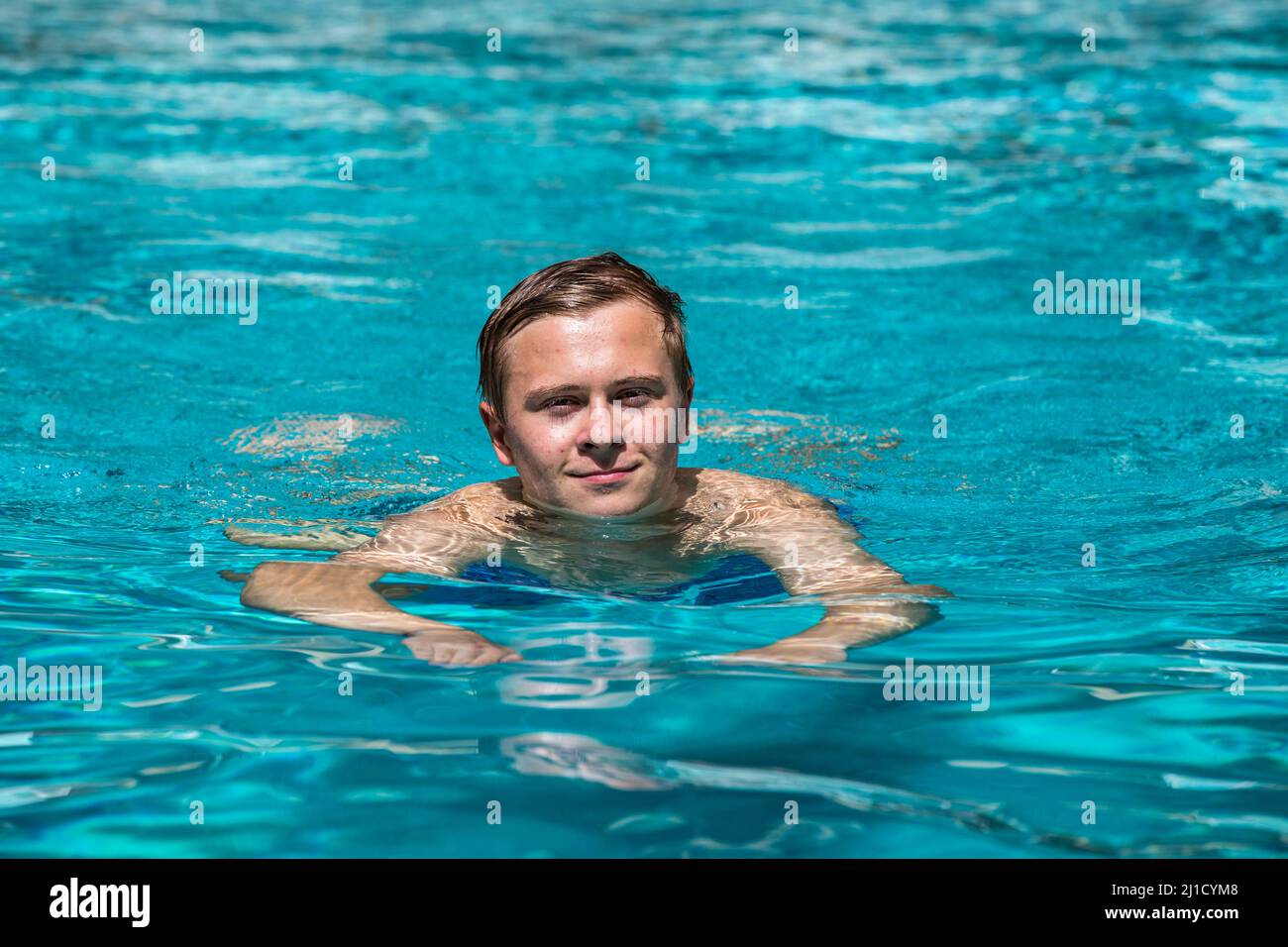 boy enjoys swimming in the outdoor swimming pool Stock Photo - Alamy