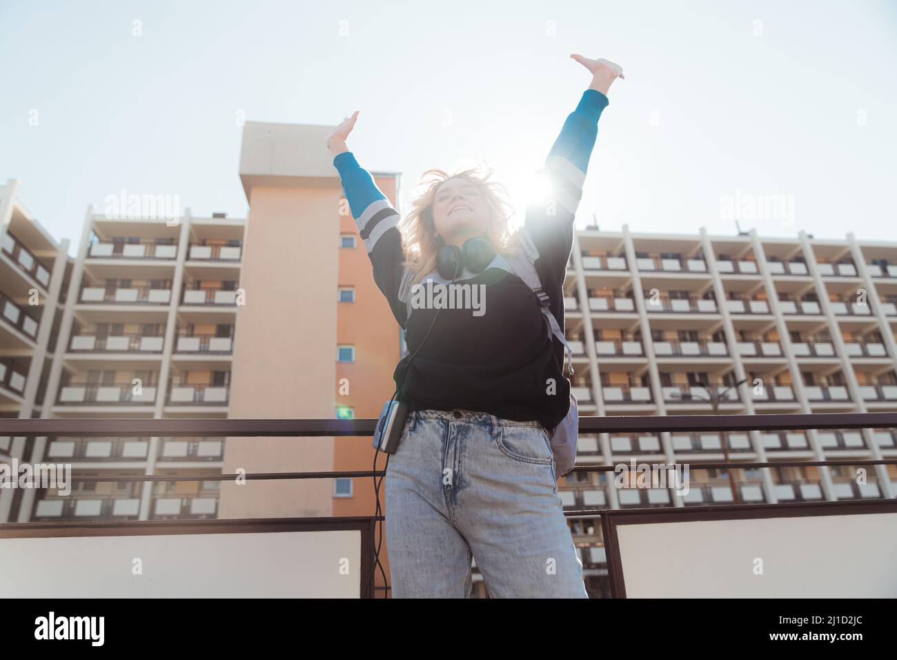 Carefree 90s-inspired caucasian girl throwing hands towards the blue ...