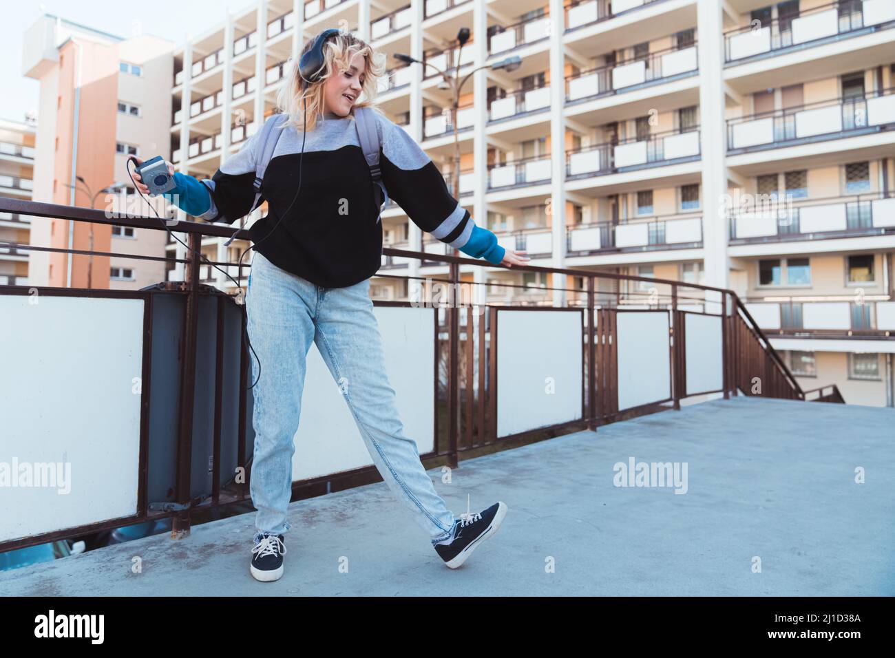 Caucasian 90s girl dancing while holding vintage audio player. Happy ...