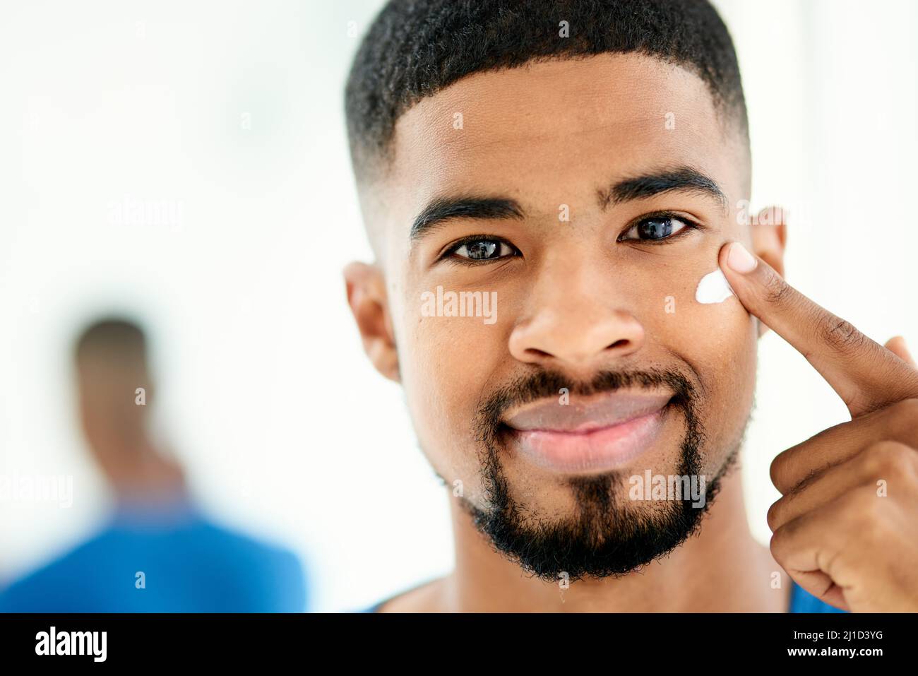 For smooth and supple skin a good moisturiser is key. Shot of a happy ...