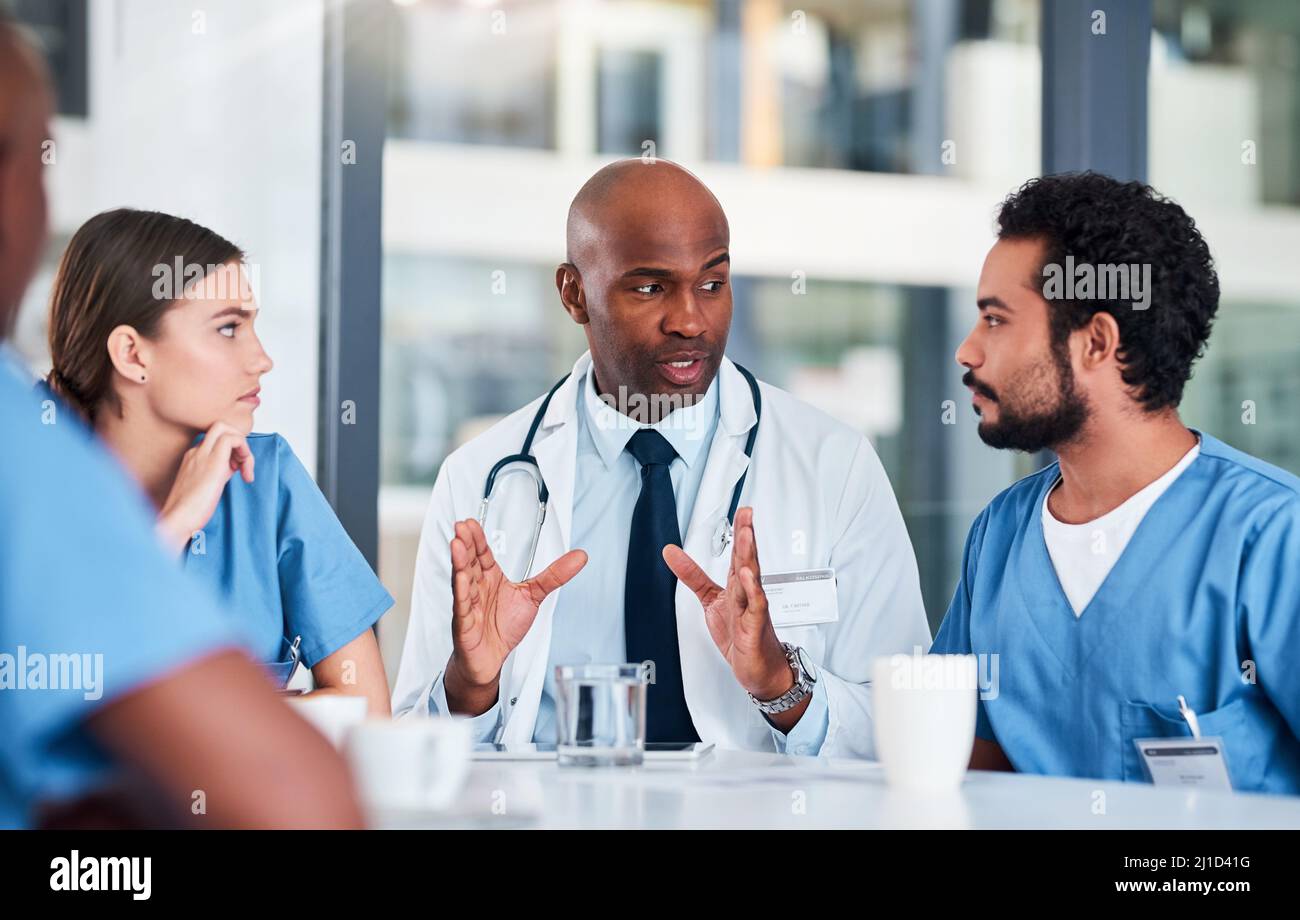 Together they save lives. Shot of a group of focused young doctors ...