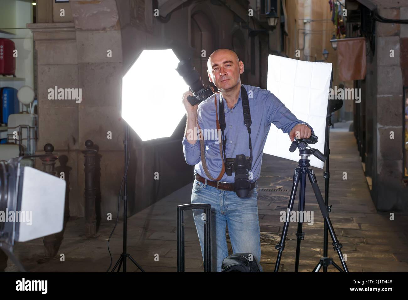 Portrait of adult photographer with his camera during photo shooting on ...