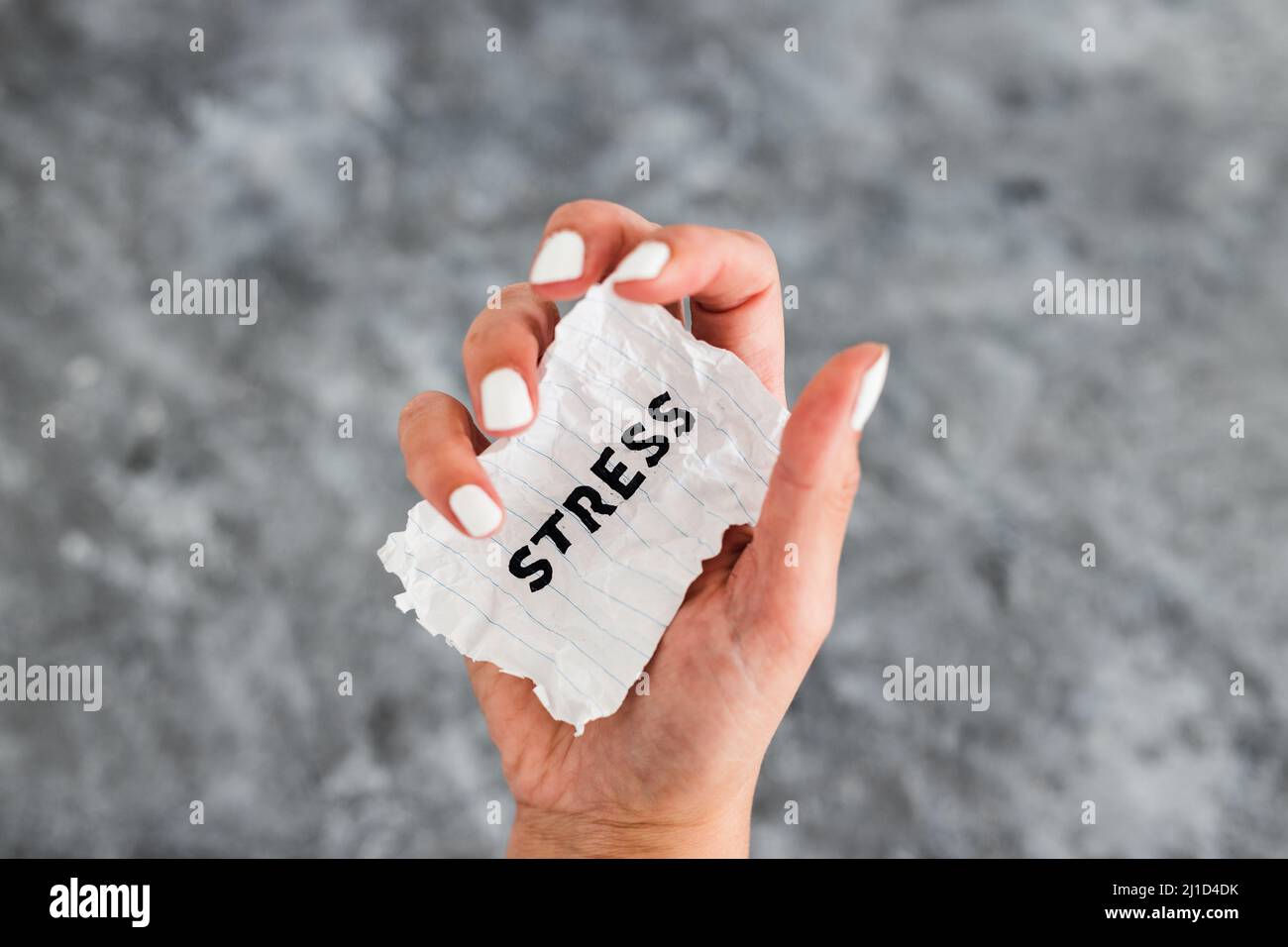 hand holding Stress text on scrunched up piece of paper, psychology or ...