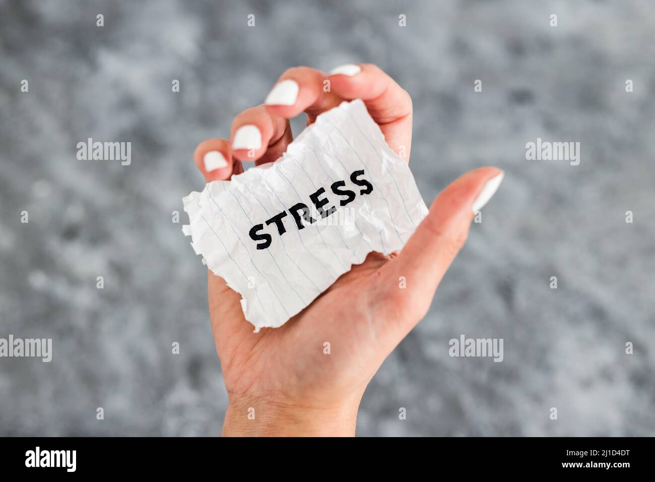 hand holding Stress text on scrunched up piece of paper, psychology or ...