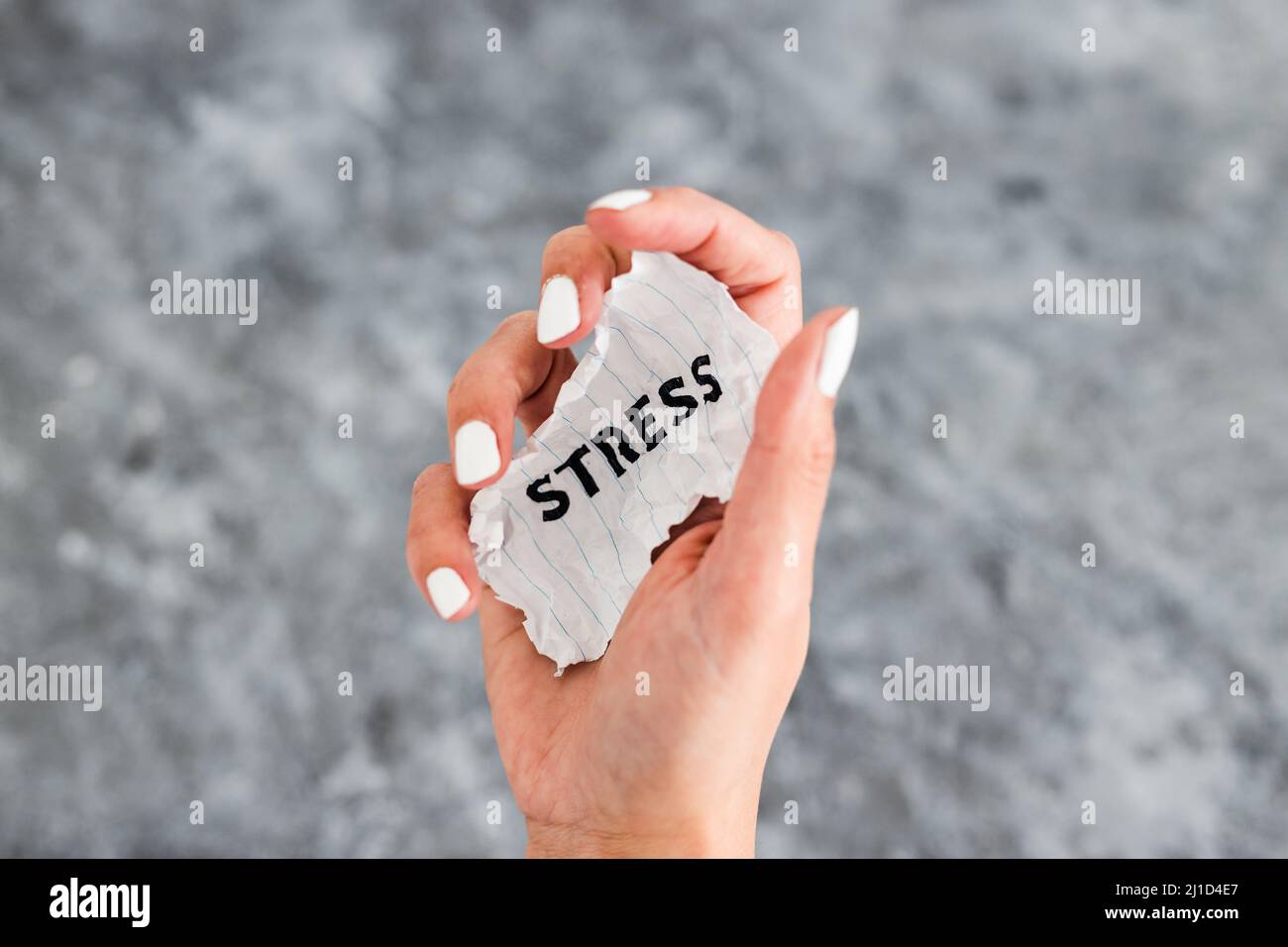 hand holding Stress text on scrunched up piece of paper, psychology or ...