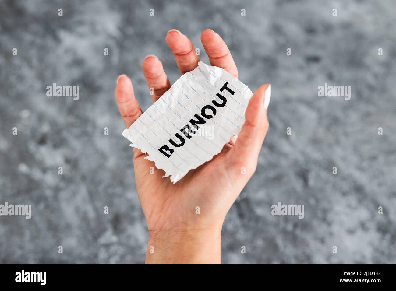 hand holding Burnout text on scrunched up piece of paper, psychology or ...