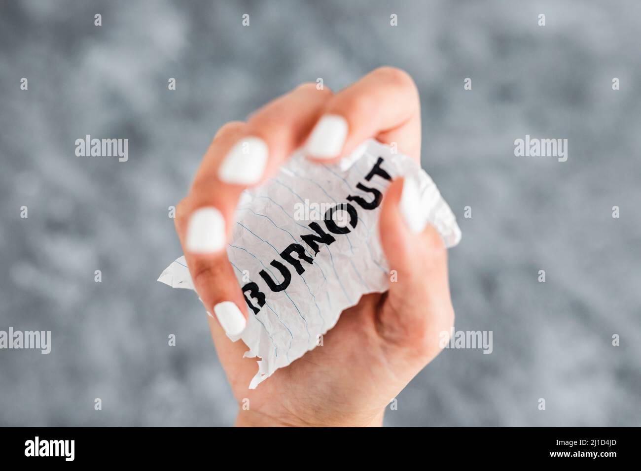 hand holding Burnout text on scrunched up piece of paper, psychology or ...