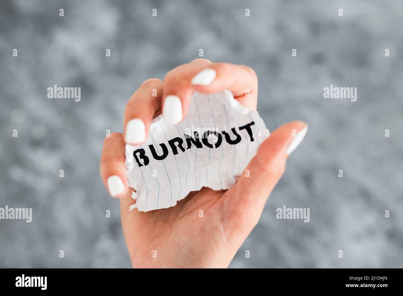 hand holding Burnout text on scrunched up piece of paper, psychology or ...